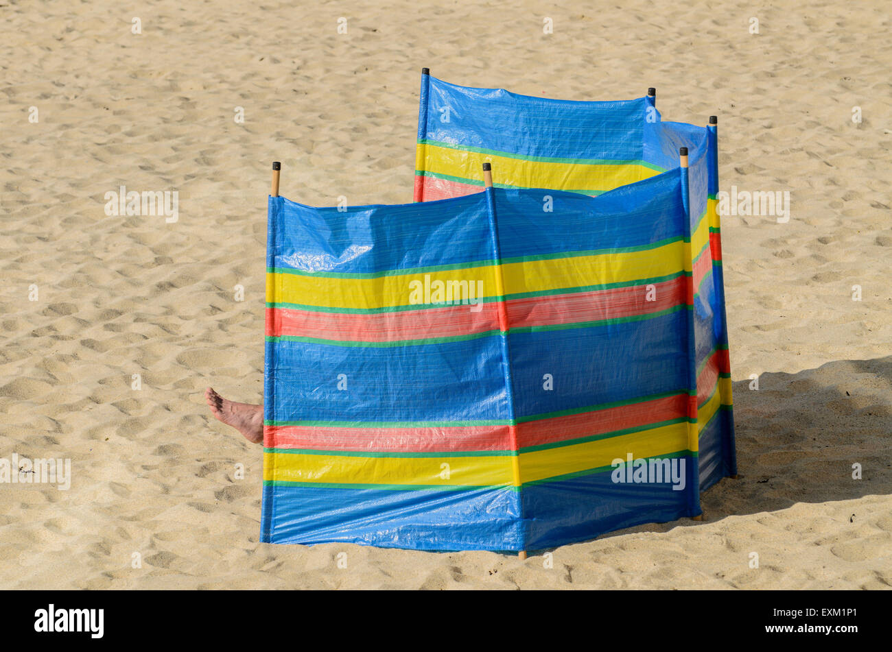 A foot protruding from the cover of a wind break on Porthmeor Beach, St ...