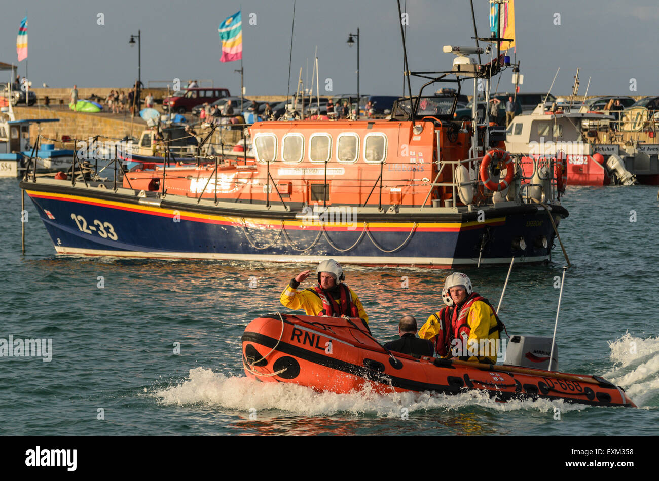 RNLI inshore Lifeboat passing the Offshore Lifeboat in the harbour, St ...