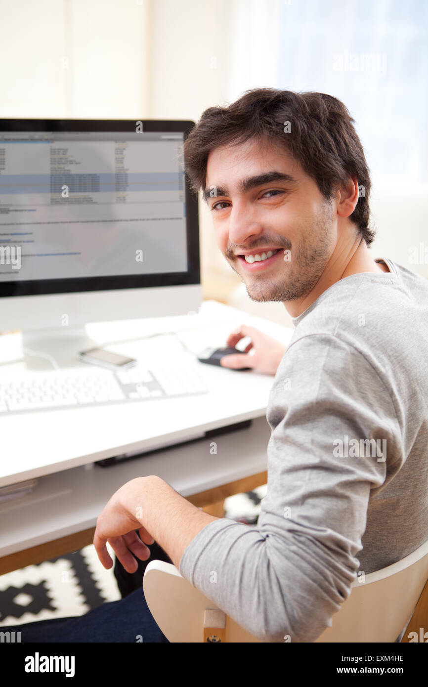 View of a Young smiling man in front of computer Stock Photo - Alamy