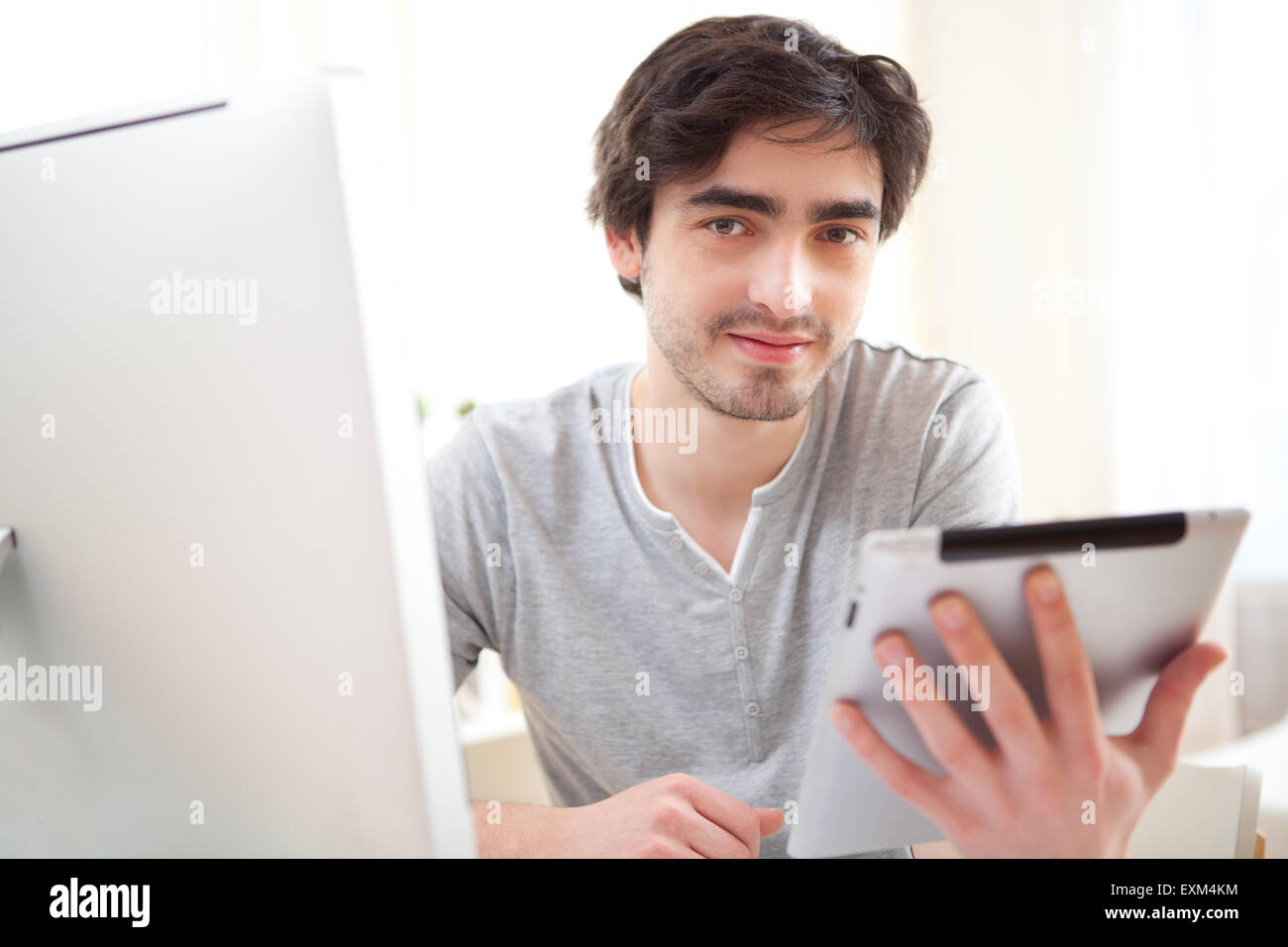 View of a young relaxed men at the office using tablet Stock Photo - Alamy