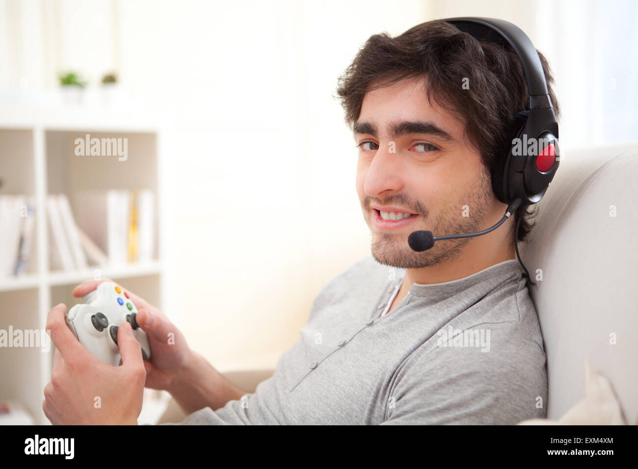 View of a Young attractive man playing video games in a sofa Stock ...