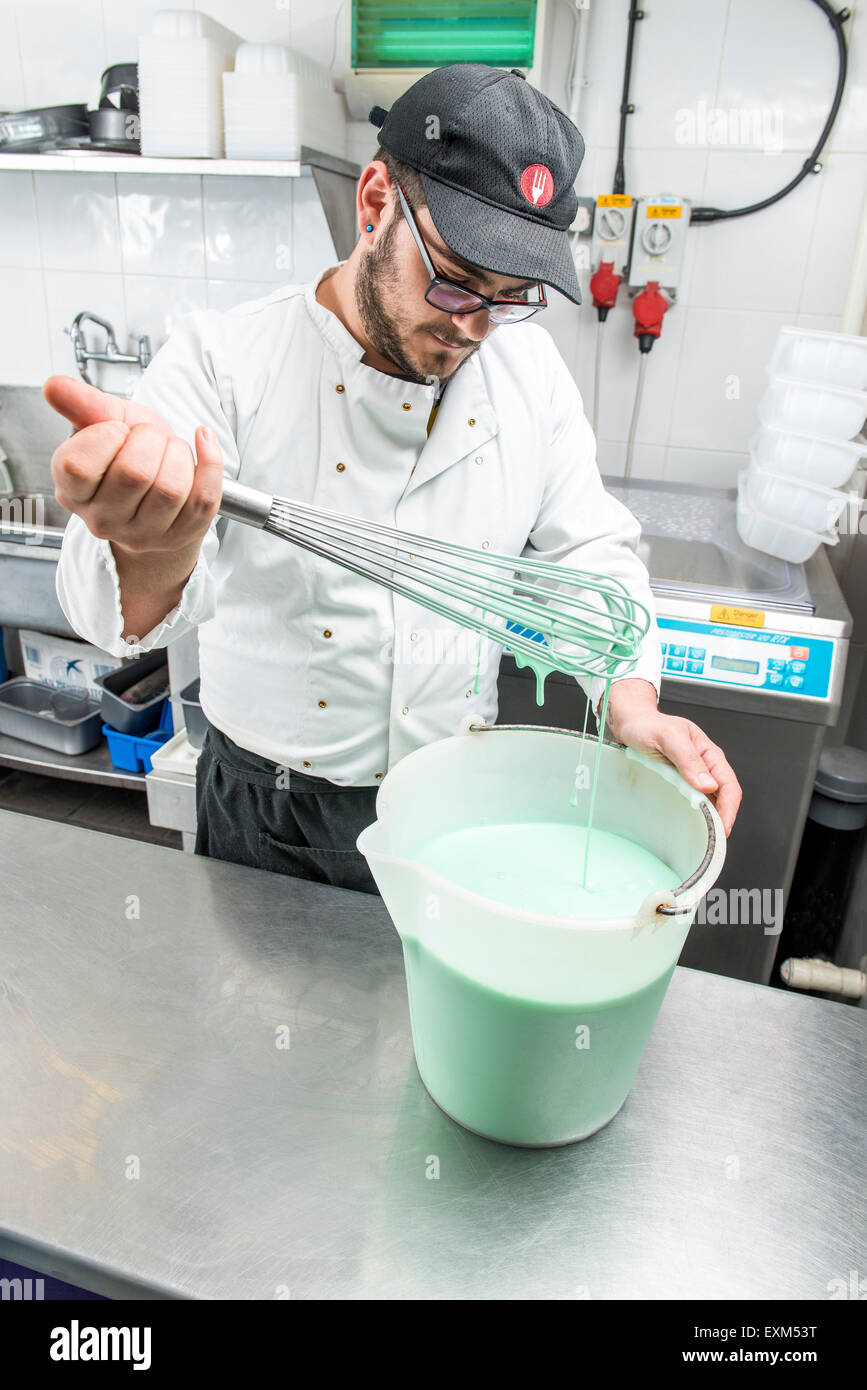 making ice cream in a professional kitchen, mixing it, adding the ...