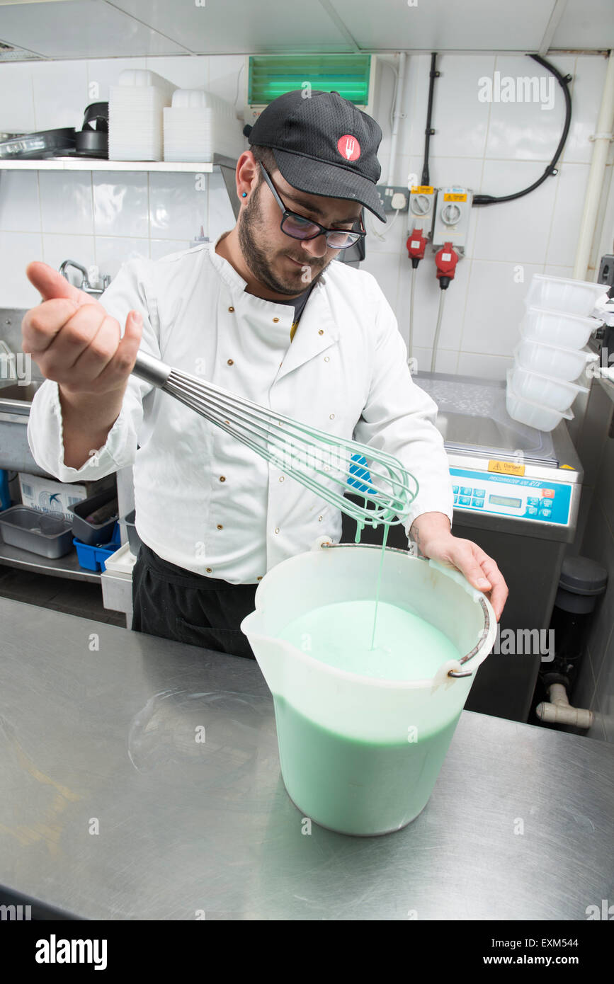 making ice cream in a professional kitchen, mixing it, adding the ...