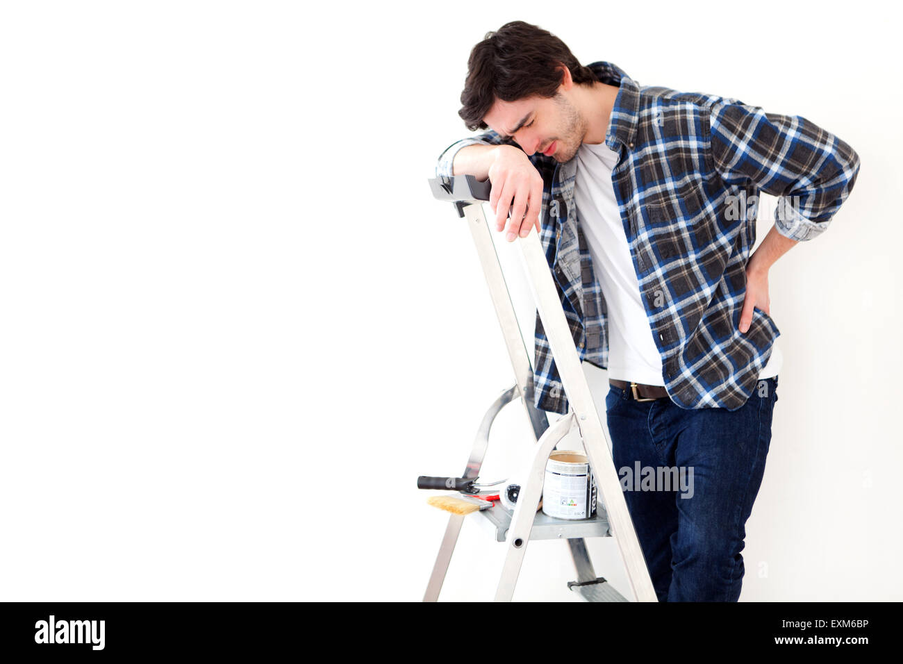 View of a Young man suffering while working on a stepladder Stock Photo ...