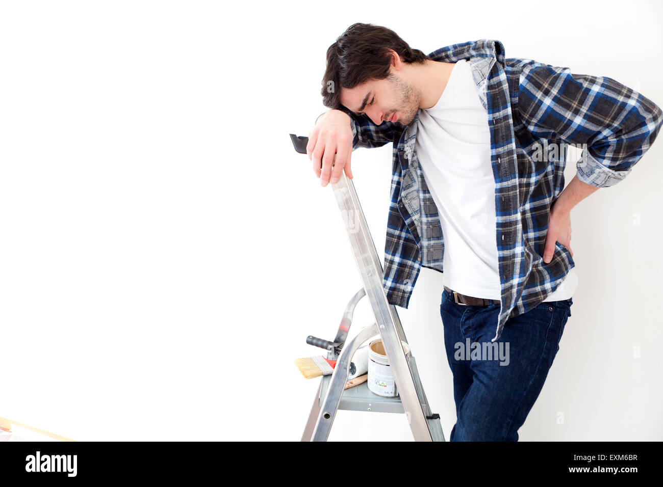 View of a Young man suffering while working on a stepladder Stock Photo ...