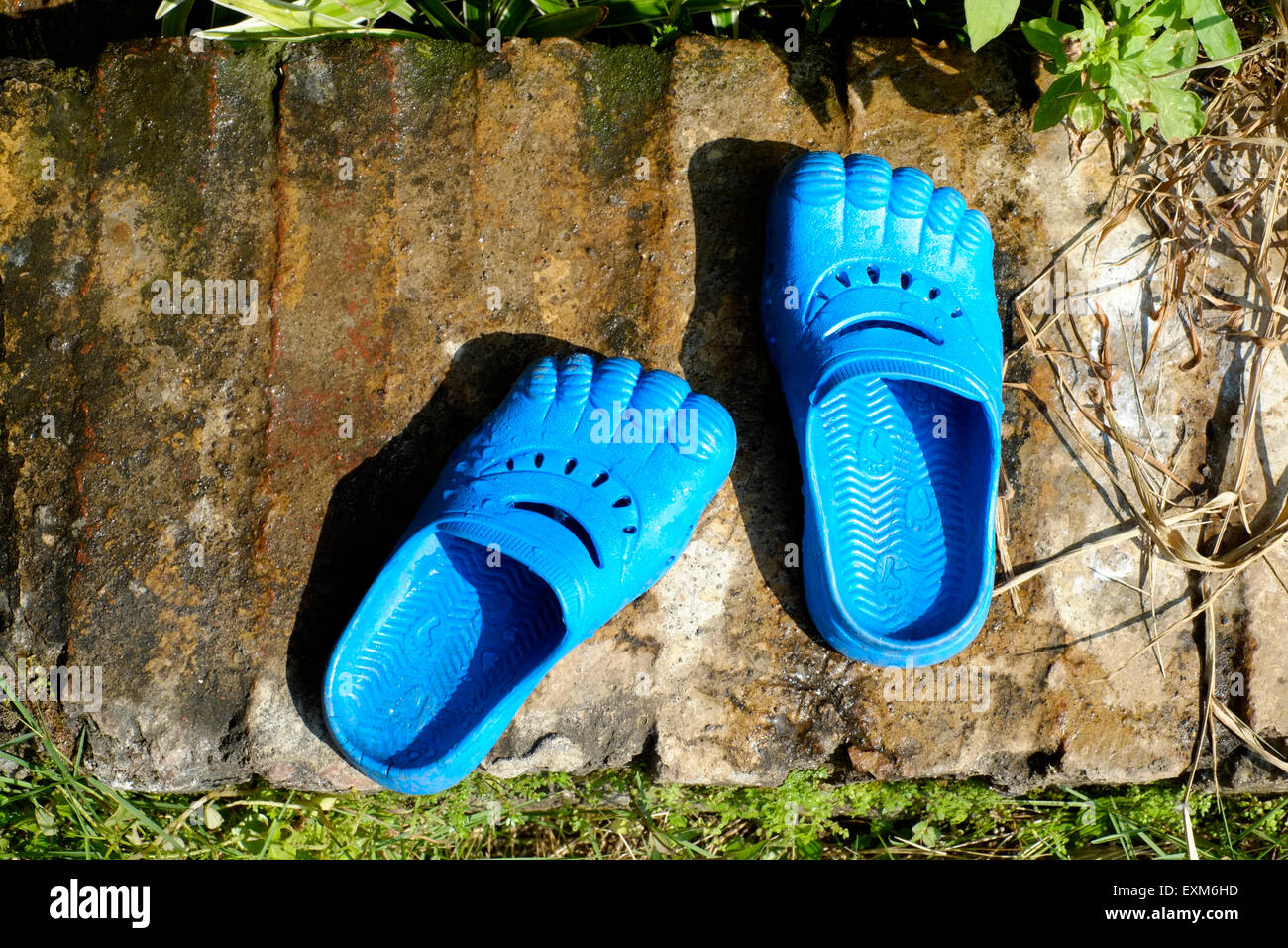 pair of children's cheap plastic sandals in the shape of feet drying in ...