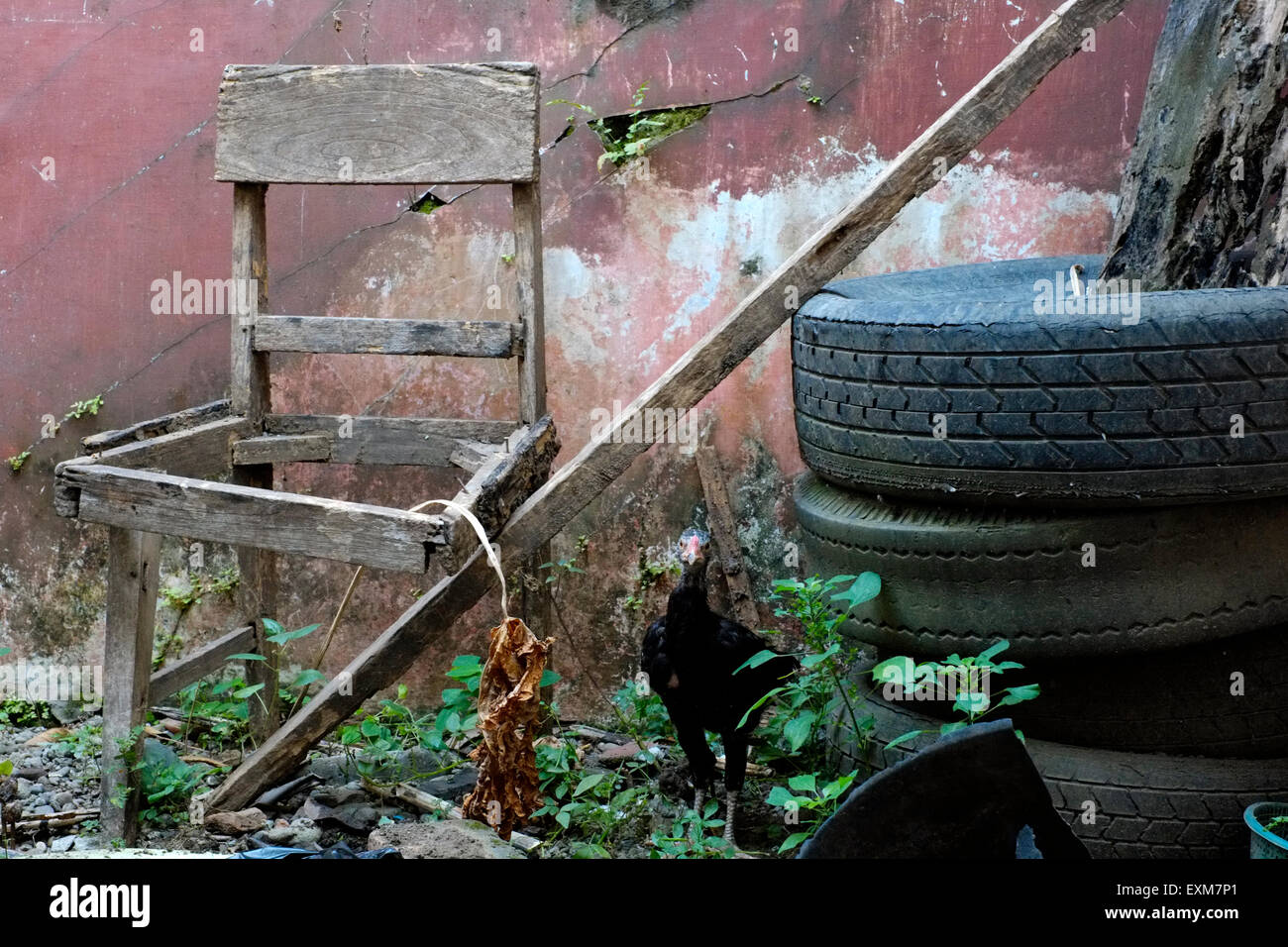 rickety wooden chair and stack of old tyres dumped in the corner of a ...