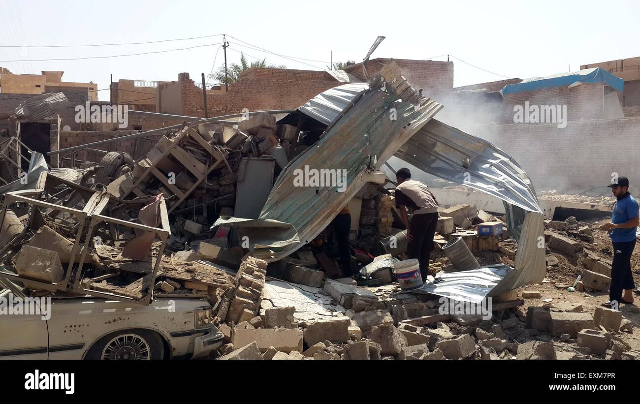 Fallujah, Iraq. 15th July, 2015. People gather around a destroyed ...