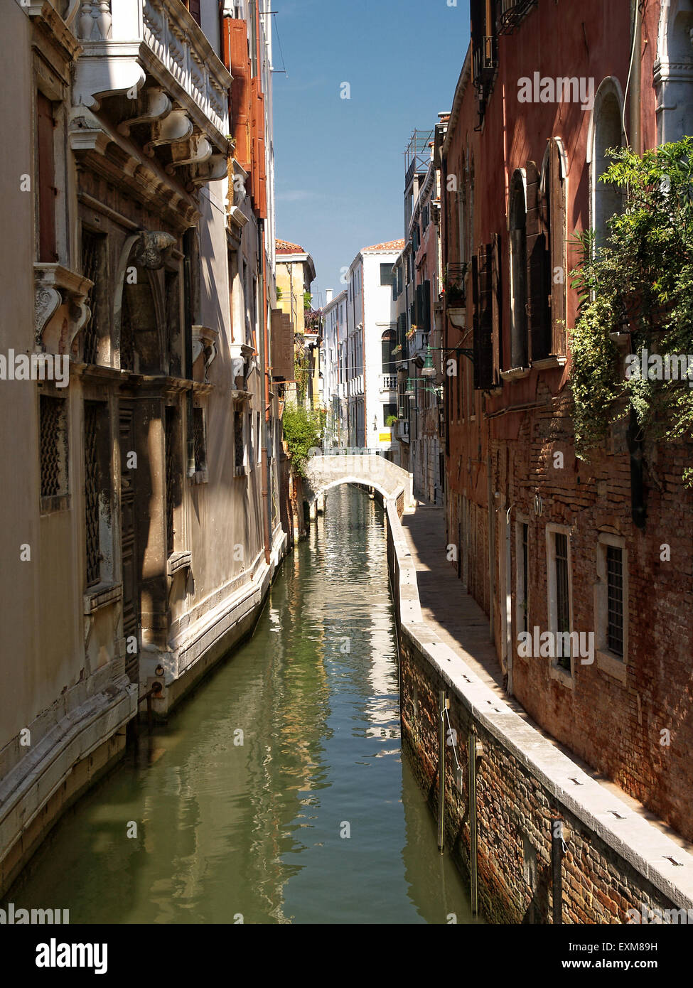View of a narrow canal in the city of Venice with nice houses on sides ...