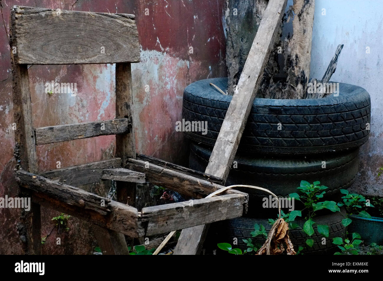 rickety wooden chair and stack of old tyres dumped in the corner of a ...