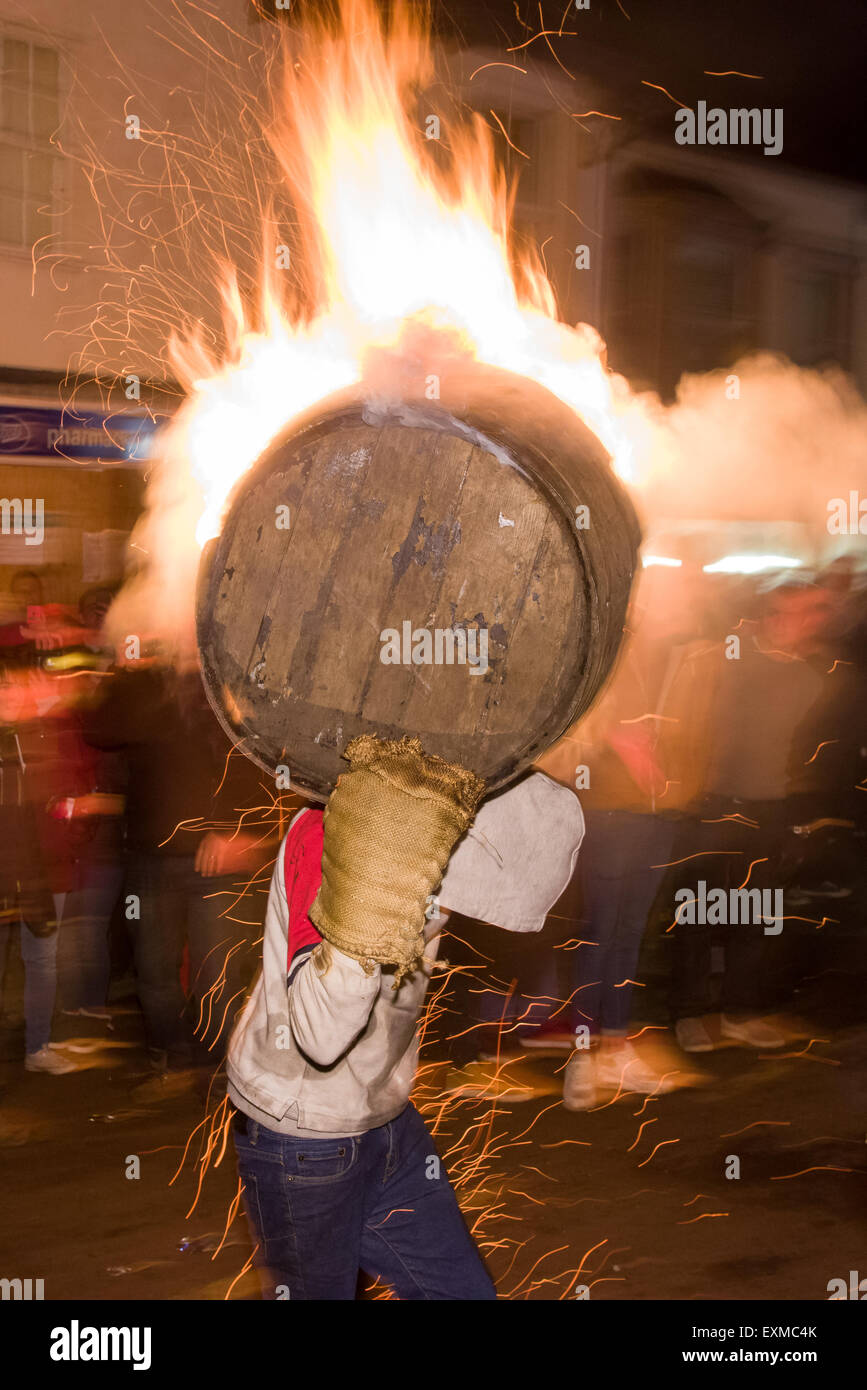 Intermediate burning barrel being carried through the street to mark ...