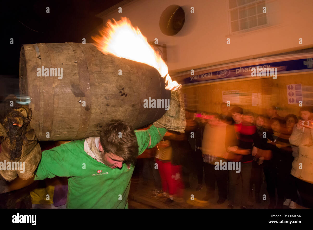 Intermediate burning barrel being carried through the street to mark ...