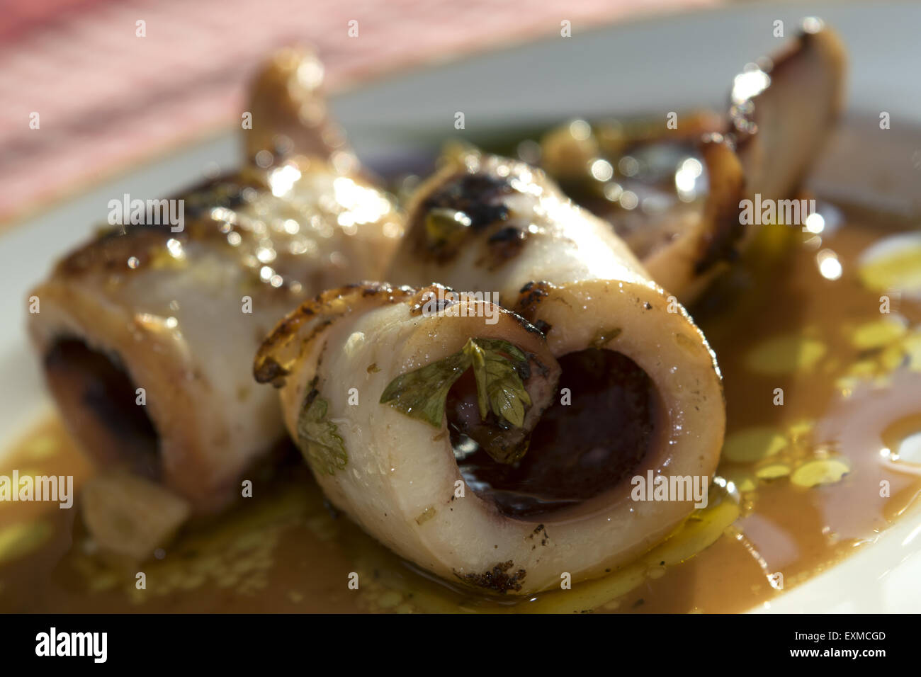 squids at the griddle with seasoning of oil and lemon Stock Photo - Alamy