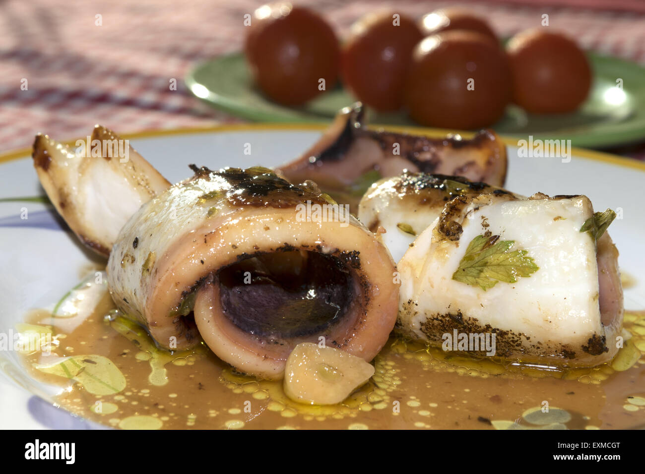 squids at the griddle with seasoning of oil and lemon Stock Photo - Alamy