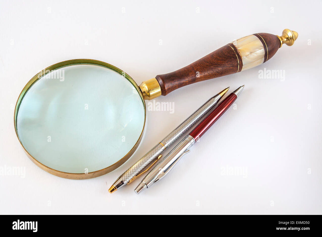 Magnifying Glass And Two Pens Stock Photo - Alamy