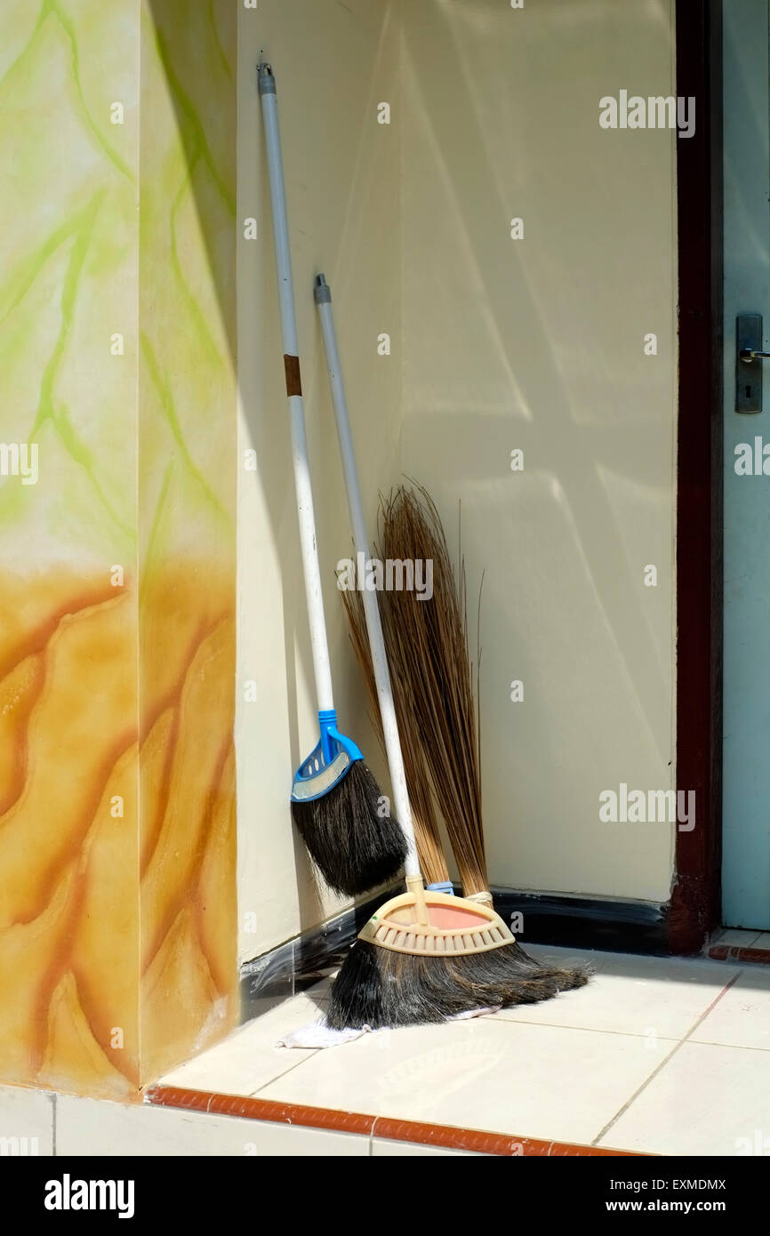 various types of traditional sweeping brushes propped up at the side of ...