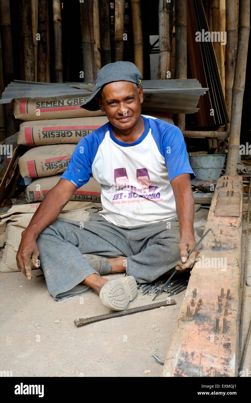 construction worker smiling while sat at his job on a building site in ...