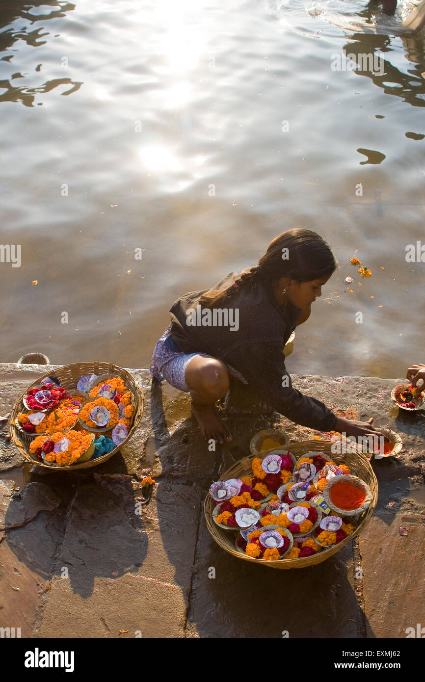 Girl selling sindoor diya deep and flowers in basket in Varanasi on ...