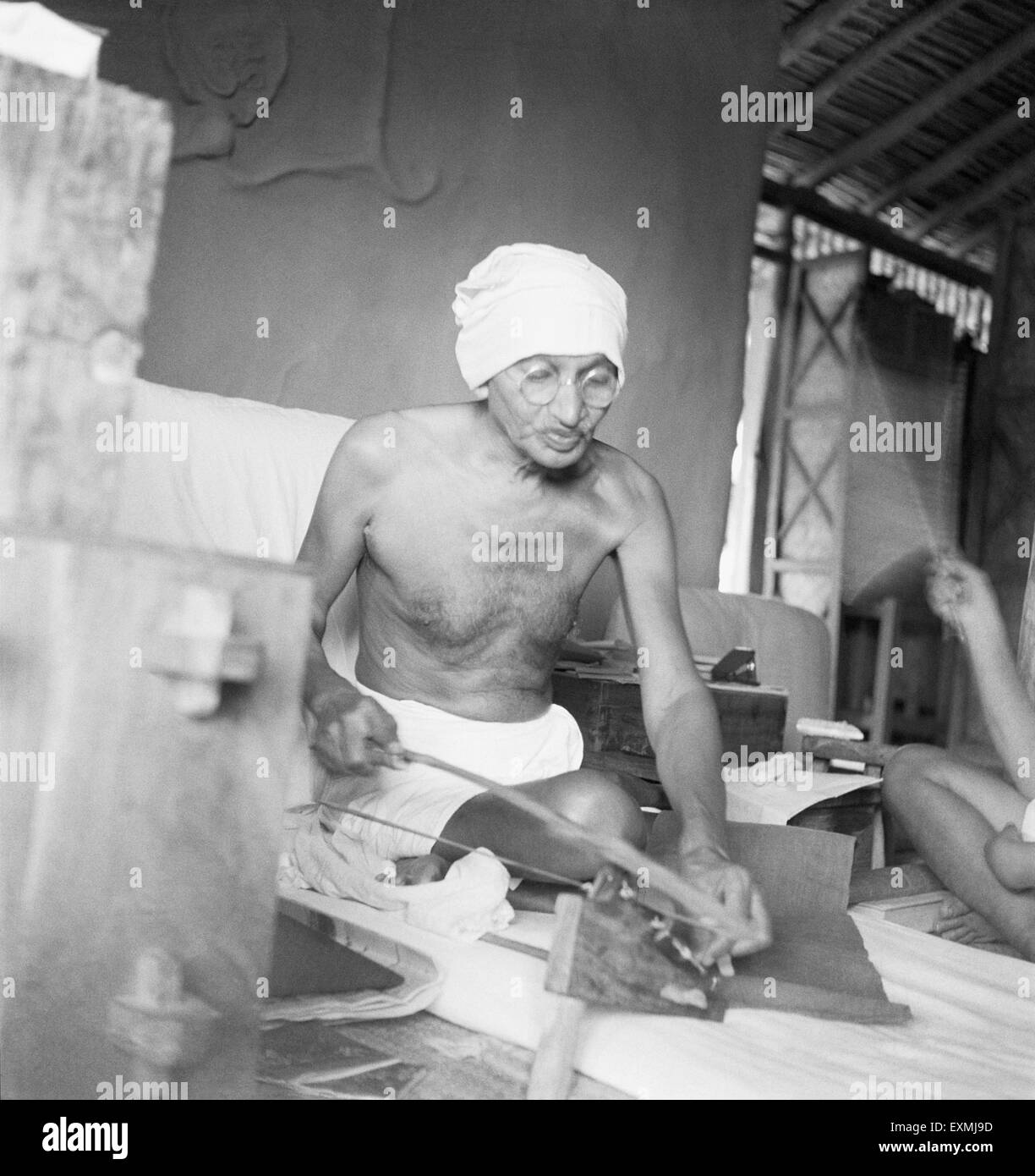 Mahatma Gandhi spinning on Dhanush Takli spinning instrument in his hut ...