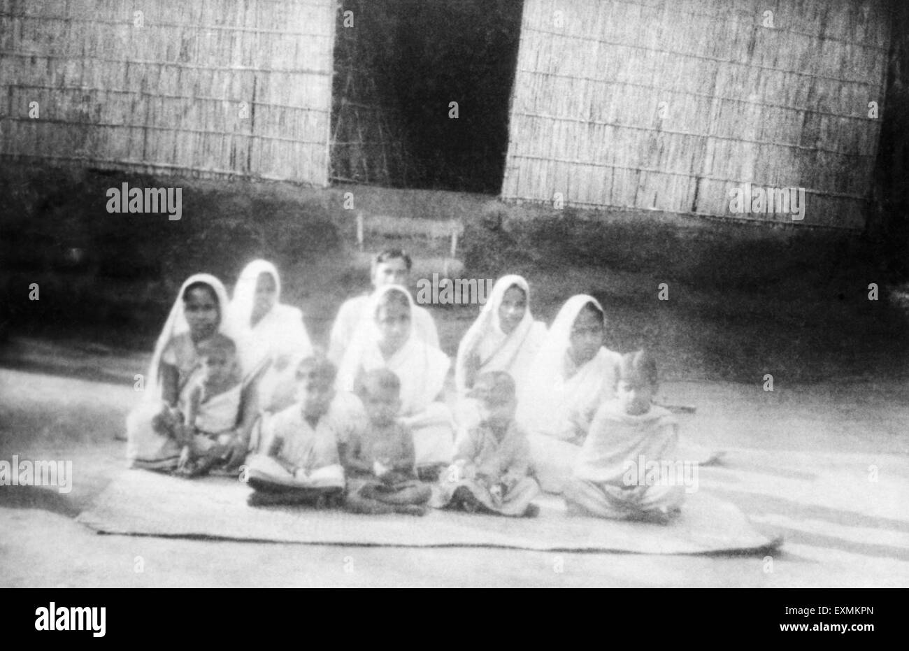 People sitting in front of a hut in the riot stricken area of Noakhali ...