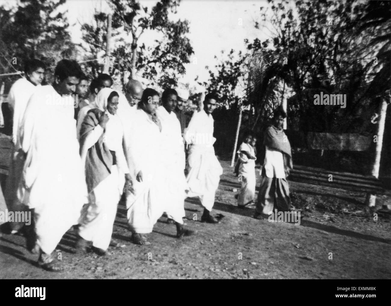 Mahatma Gandhi supported Amtus Salam and another woman ; walking with ...