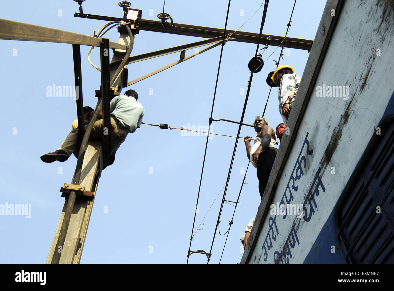 Workers repairing overhead wires of Railway line, Bombay, Mumbai ...
