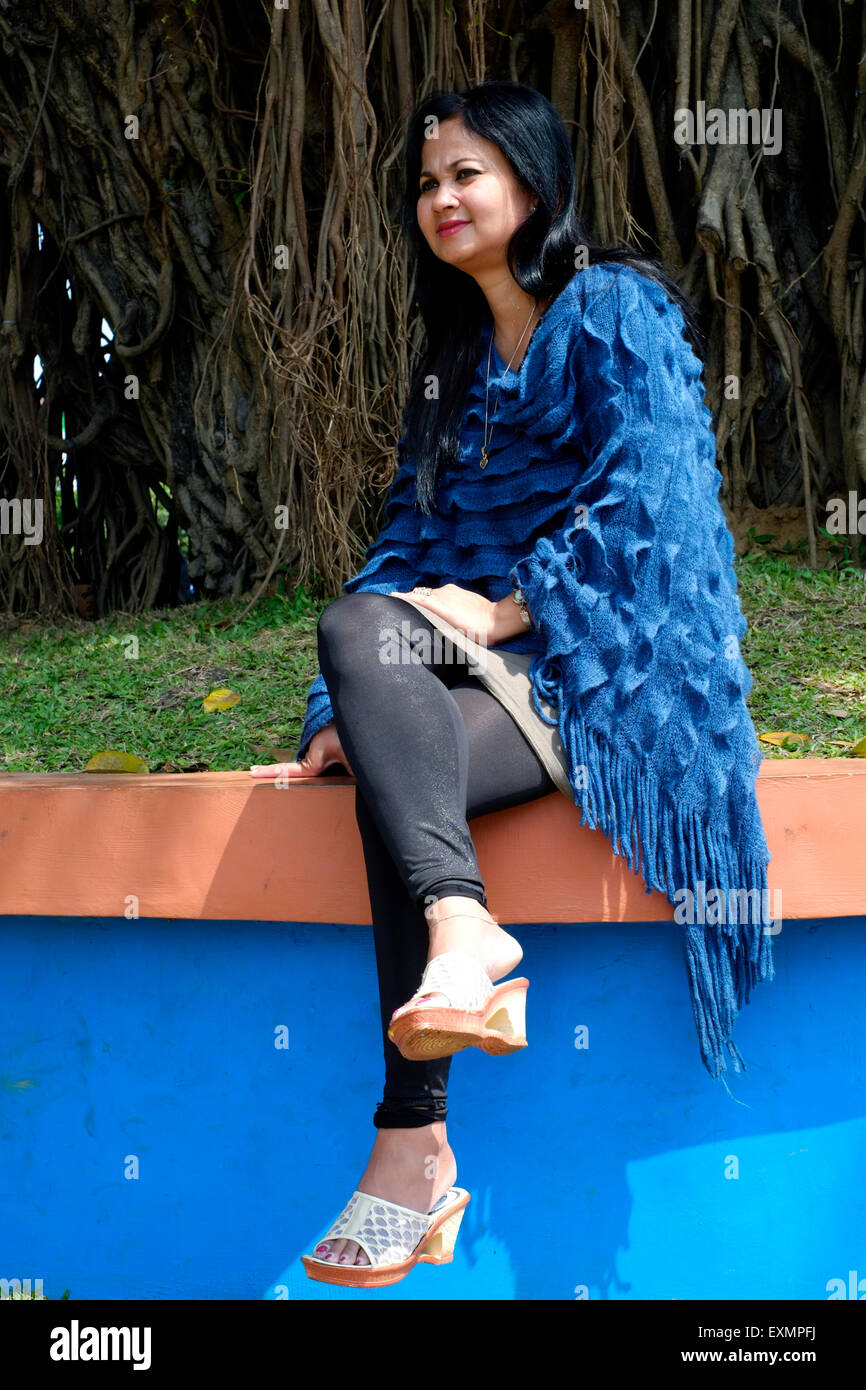 pretty well dressed local female posing in front of tree with large ...