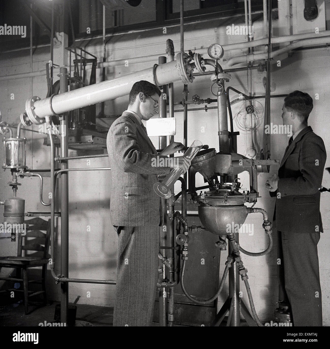 1950s, historical, engineering student in factory operating a funnel ...