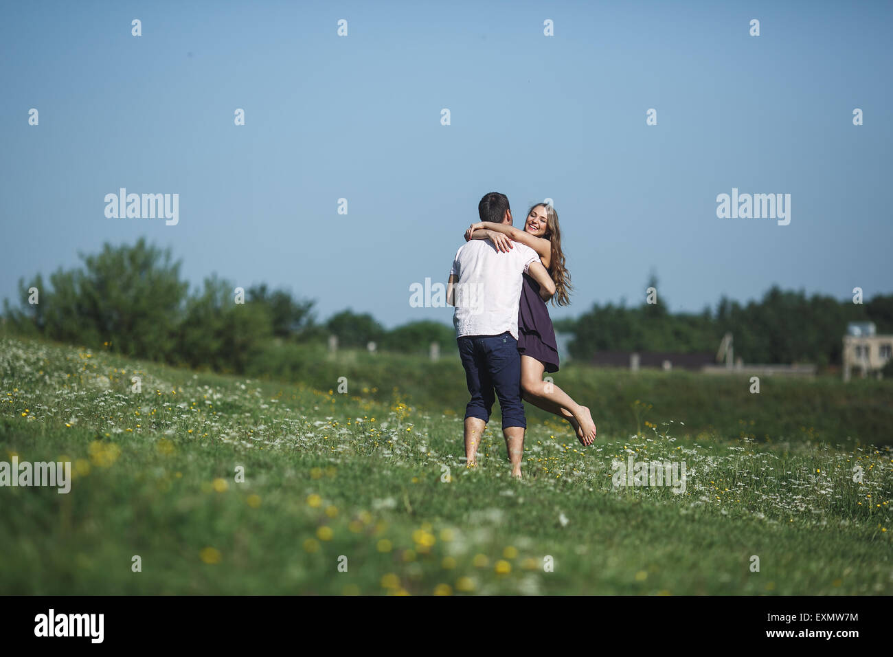 Couple running in field and have fun Stock Photo - Alamy