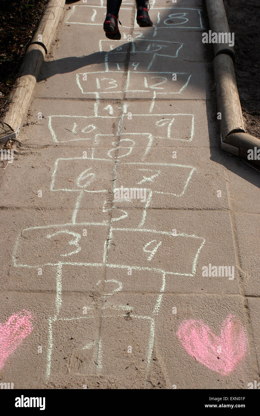 Girl playing on a self-made hopscotch lane with hearts Stock Photo - Alamy