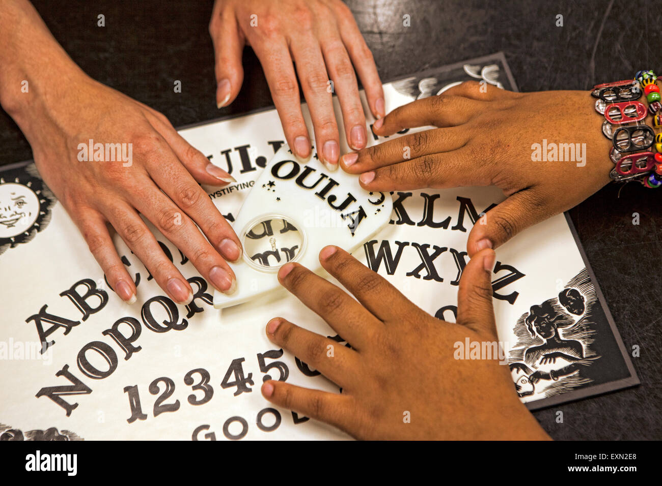 Close up of two teenager's hands playing with a Ouija Board Stock Photo ...