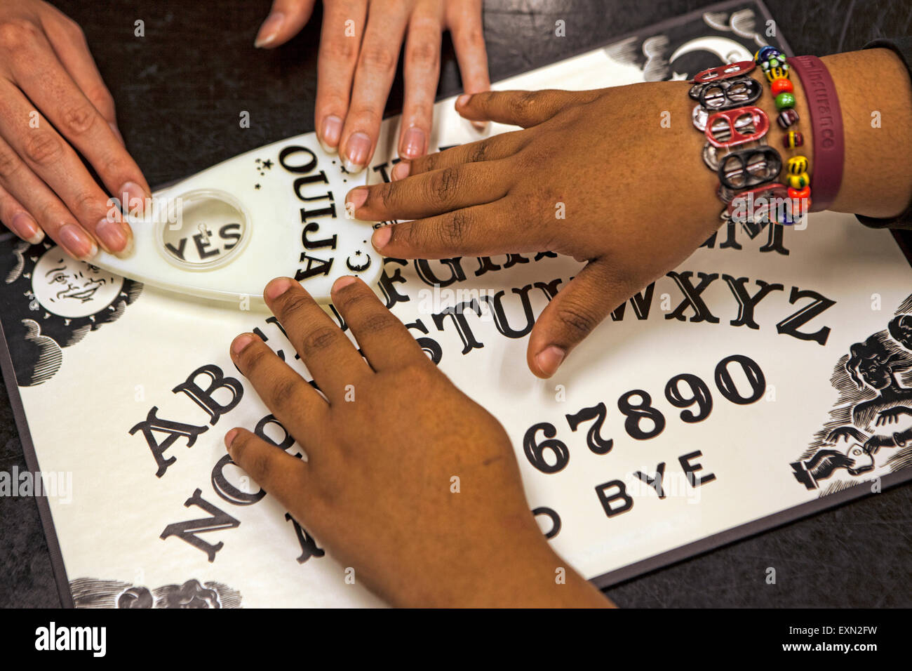 Close up of two teenager's hands playing with a Ouija Board Stock Photo ...