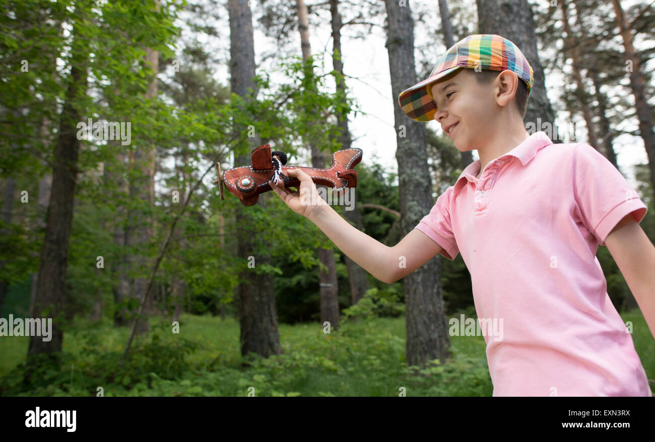 Boy playing with wooden plane in forest Stock Photo - Alamy