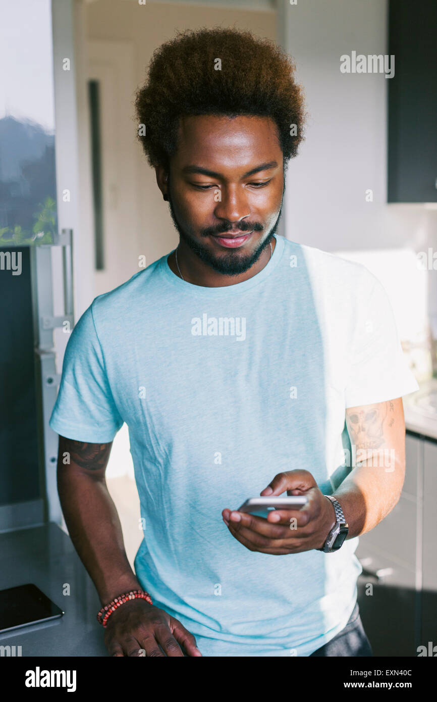 Young man looking at his smartphone Stock Photo - Alamy