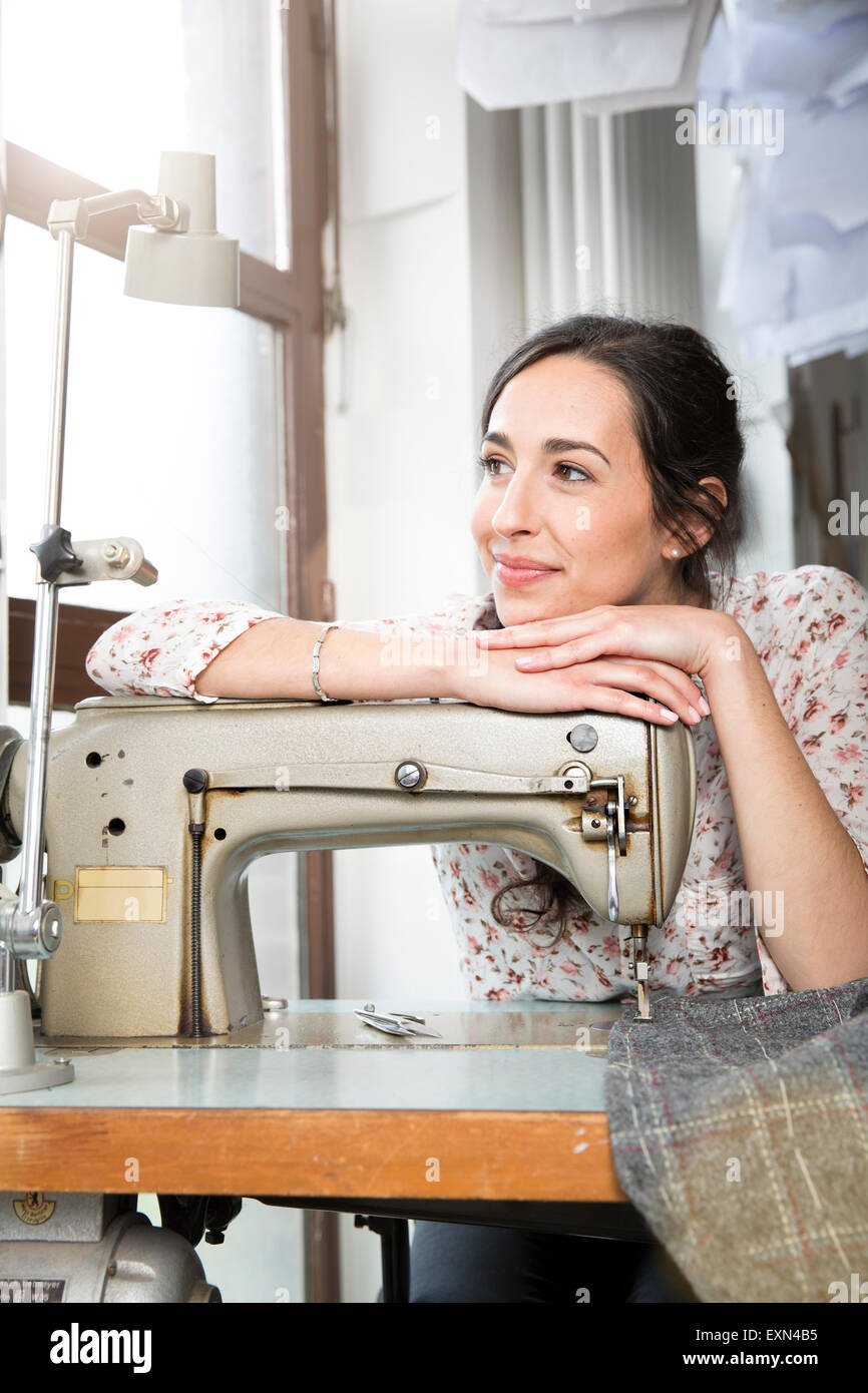 Young seamstress with sewing machine in manufacturer's workshop Stock ...