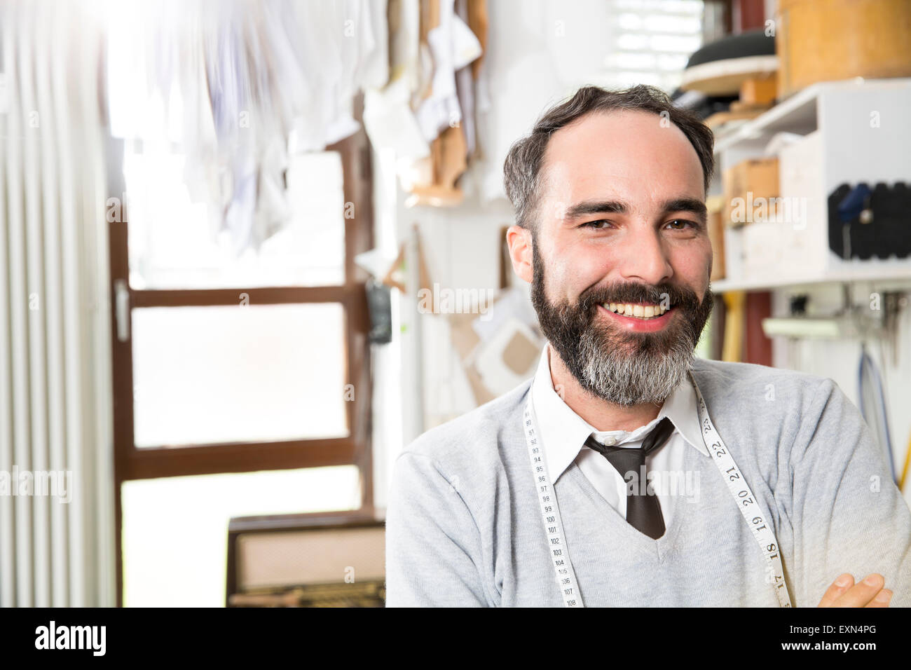 Tailor standing in his workshop with arms crossed Stock Photo - Alamy