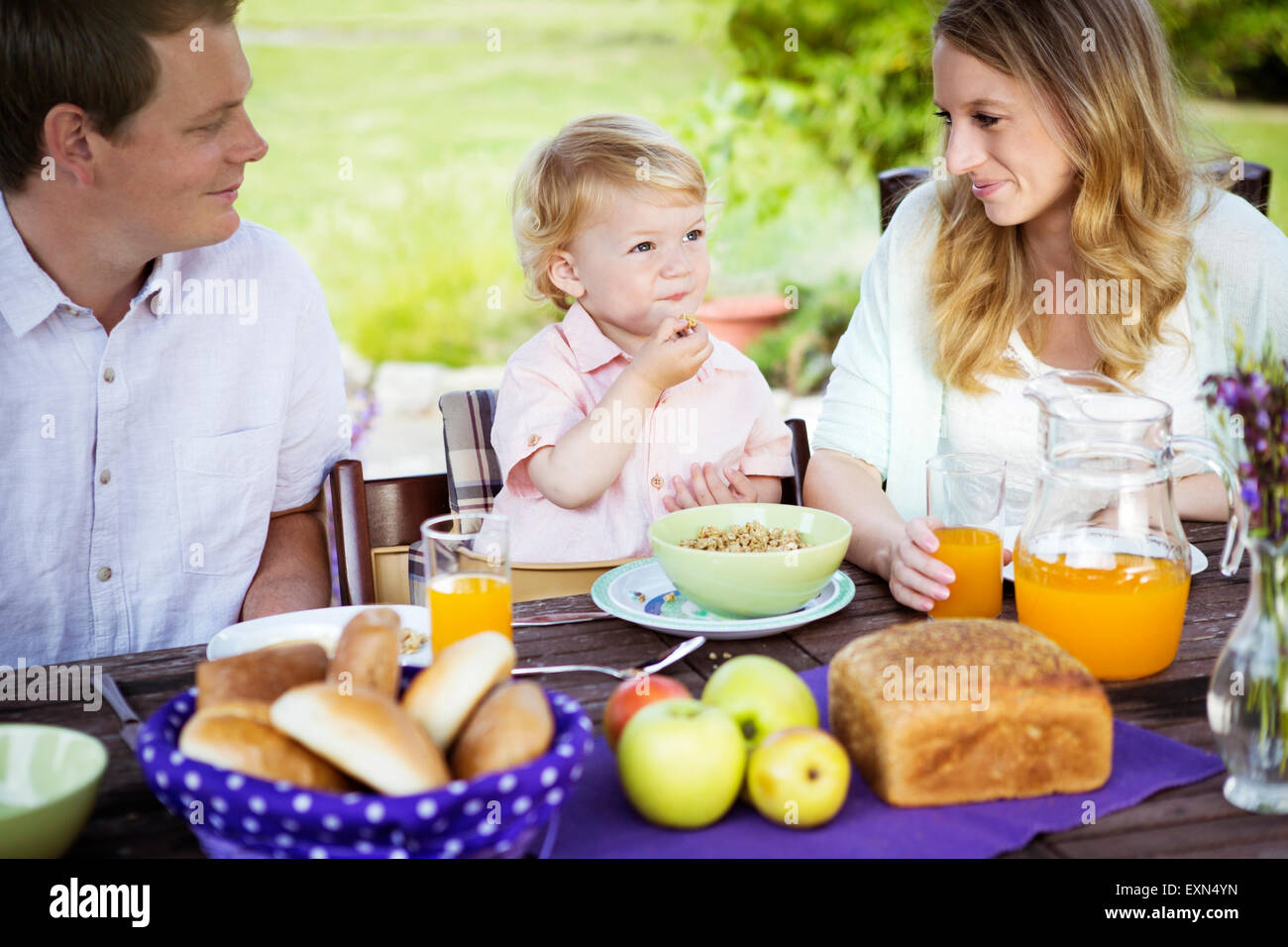 Happy family sitting at breakfast table Stock Photo - Alamy
