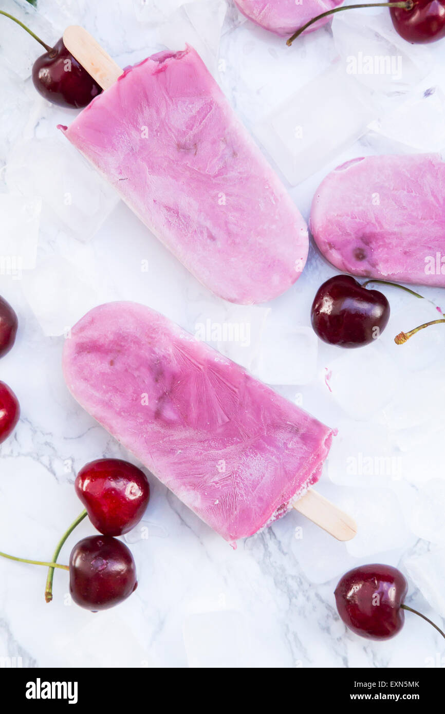 Cherry yoghurt ice lollies and cherries on white marble Stock Photo - Alamy
