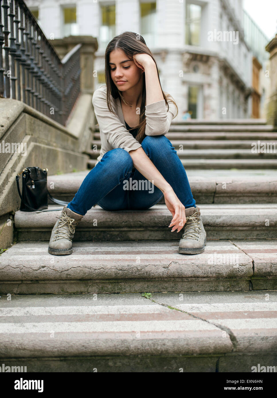 Spain, Oviedo, young woman sitting on stairs in the old town Stock ...