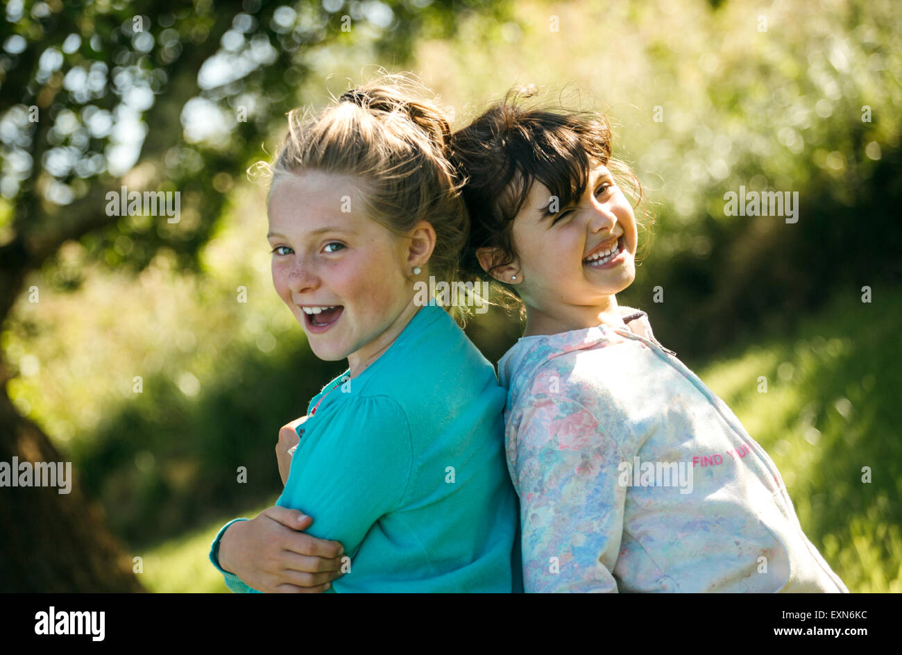 Two girls back to back Stock Photo - Alamy