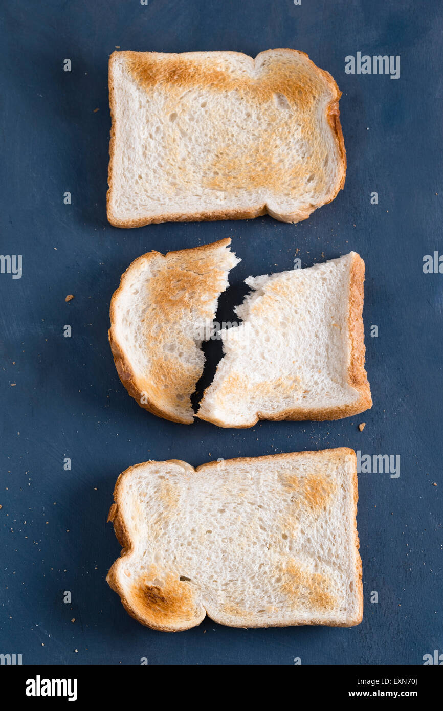 Toasted bread slices on blue background, broken-up Stock Photo - Alamy