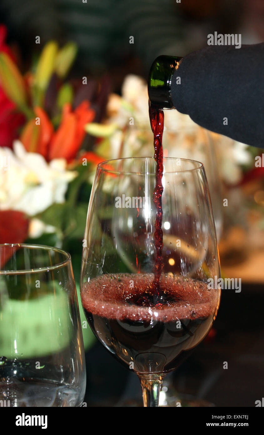 Pouring red wine into the glass in restaurant Stock Photo - Alamy