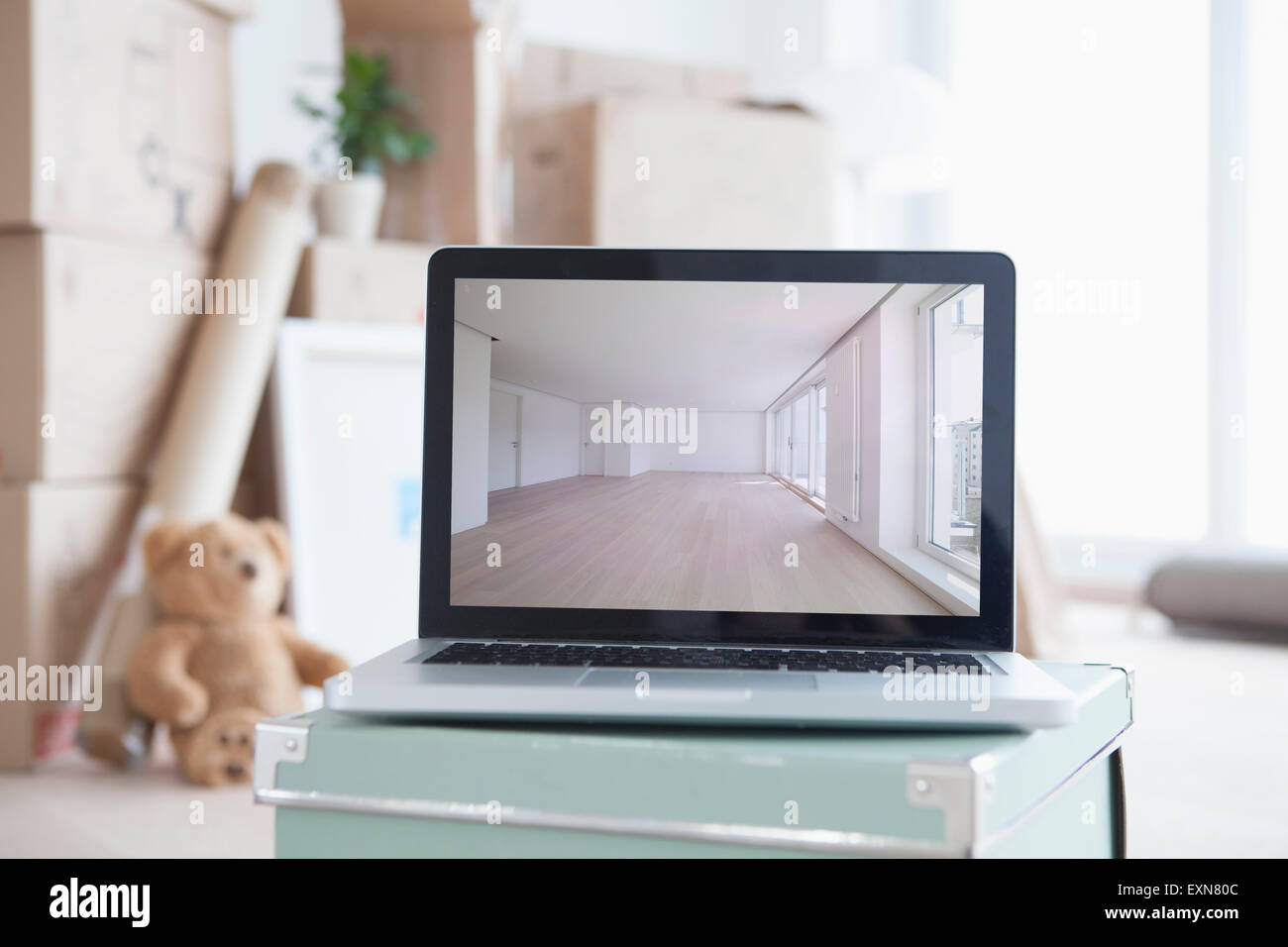 Laptop with picture of empty room in front of piled cardboard boxes ... Laptop with picture of empty room in front of piled cardboard boxes ...