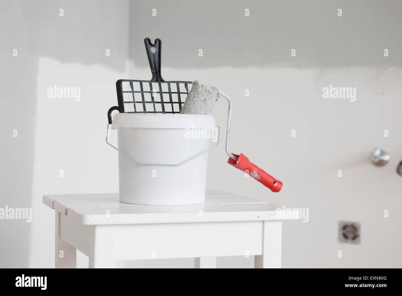 Paint bucket and roll on white table Stock Photo - Alamy