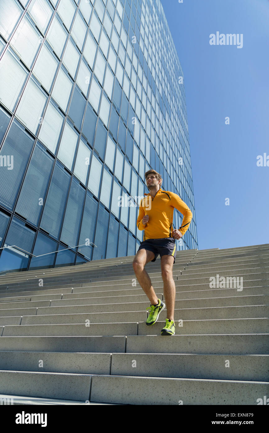 Athlete running downstairs at high-rise building Stock Photo - Alamy