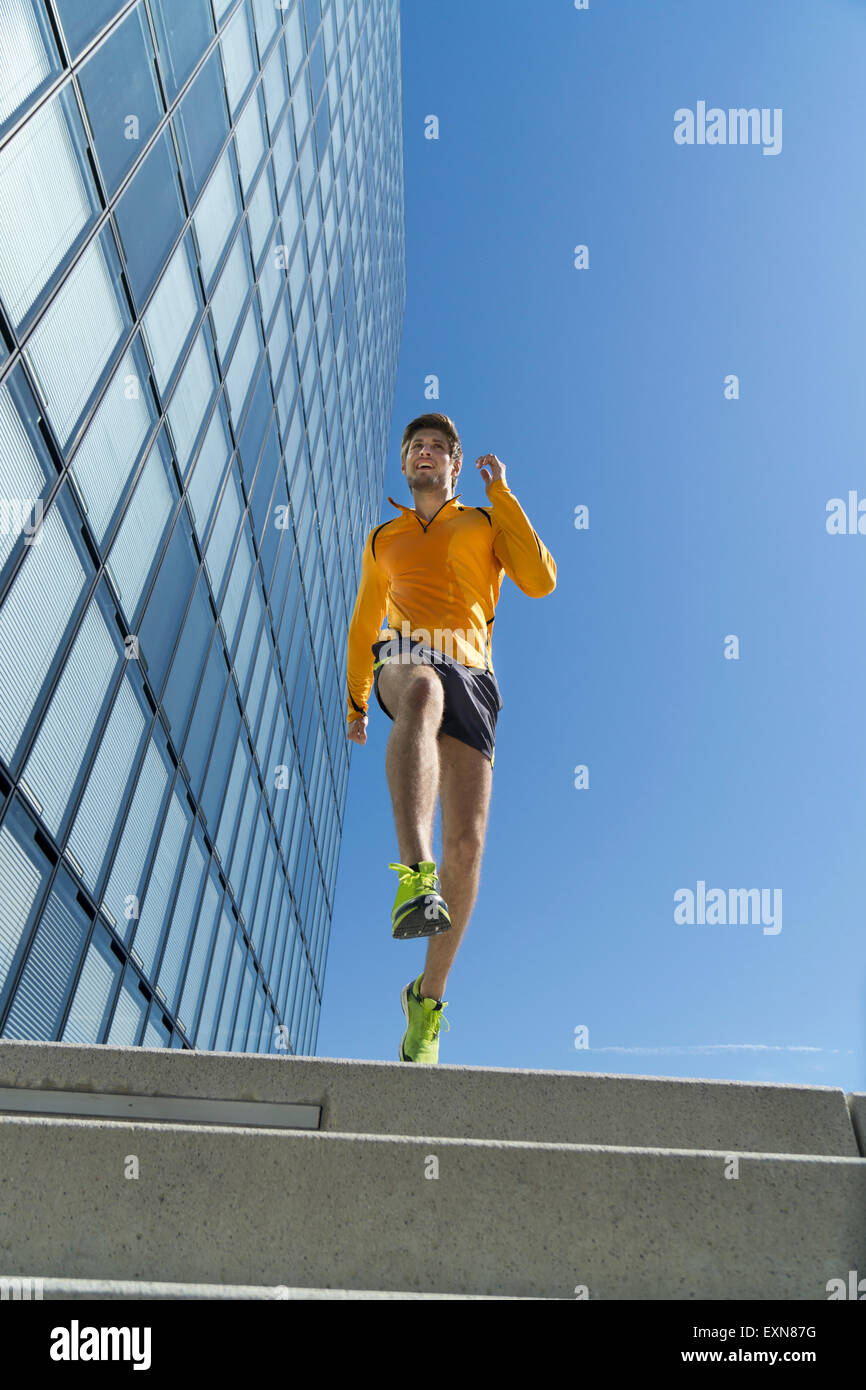 Athlete running at high-rise building Stock Photo - Alamy