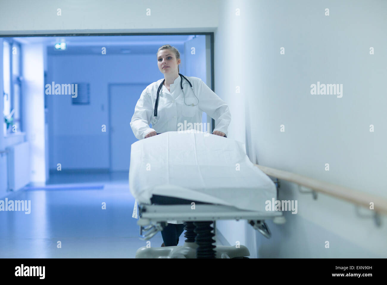 Young doctor on hospital floor pushing bed Stock Photo - Alamy