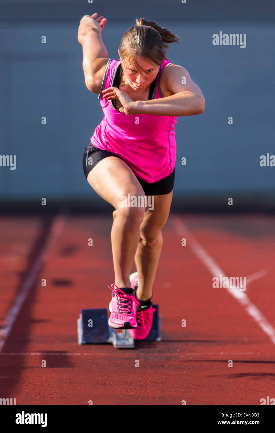 Sprinter starting on tartan track Stock Photo - Alamy