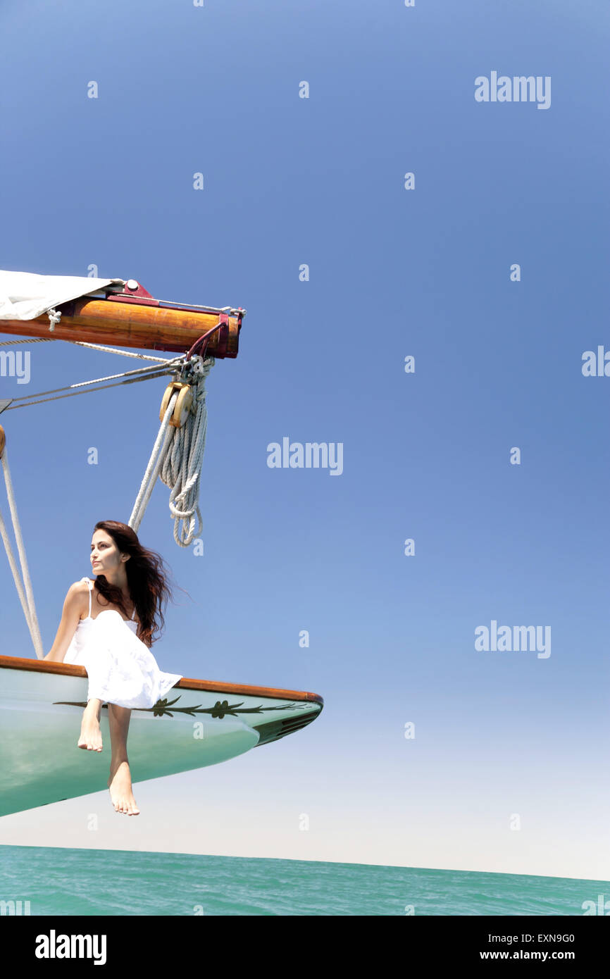 Brunette young woman on a sailing trip sitting on bow Stock Photo - Alamy