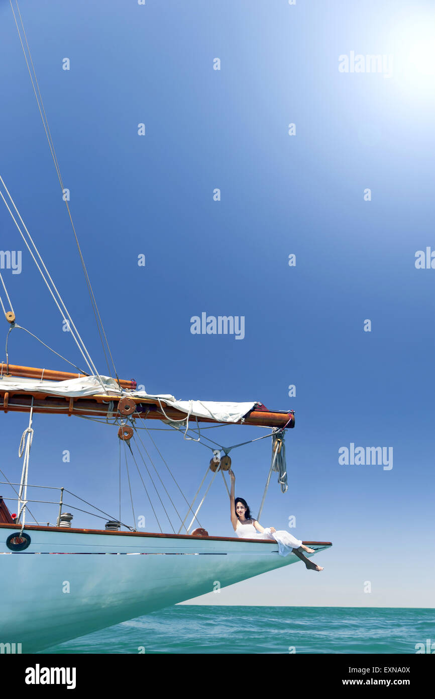 Young woman on a sailing trip sitting on bow Stock Photo - Alamy
